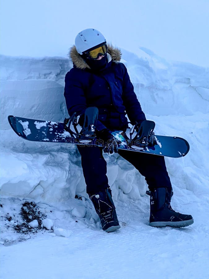 Ski Base, Resort. a Man with a Snowboard in the Helmet Rides from the ...