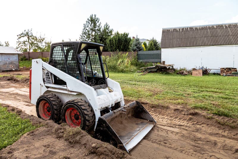A Skid Steer Loader Clears the Site for Construction. Land Work by the ...