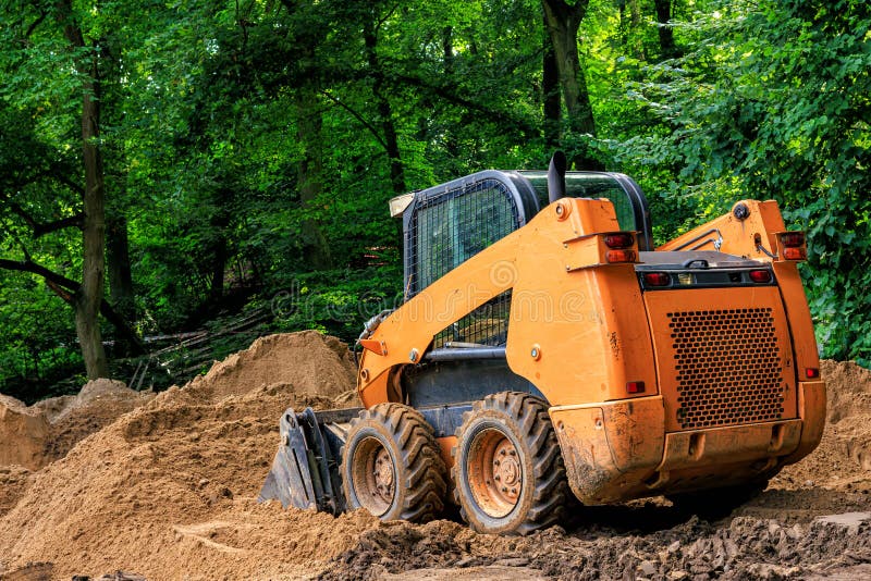 A Skid Steer Loader Shovels Soil in a Park Stock Image - Image of ...