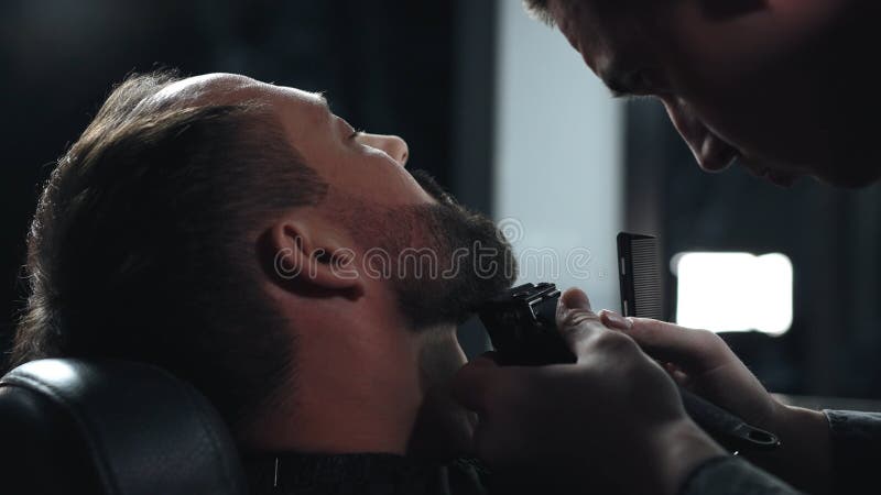 Skilled Barber Grooming Clients Beard Using Electric Razor, Delivering ...