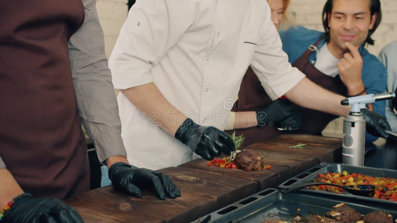 Skilled Cook Teaching Group of Students To Cook Meals with Fire, People ...