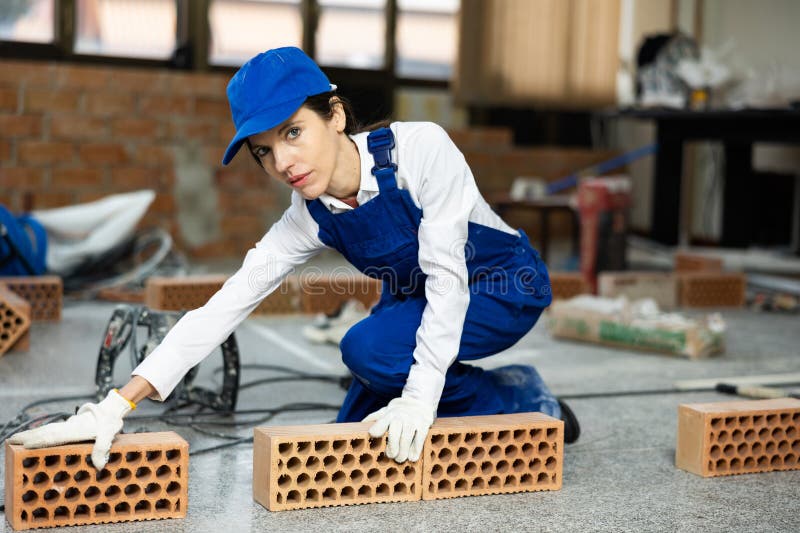 Female Builder Arranging Bricks Inside Building Under Construction ...