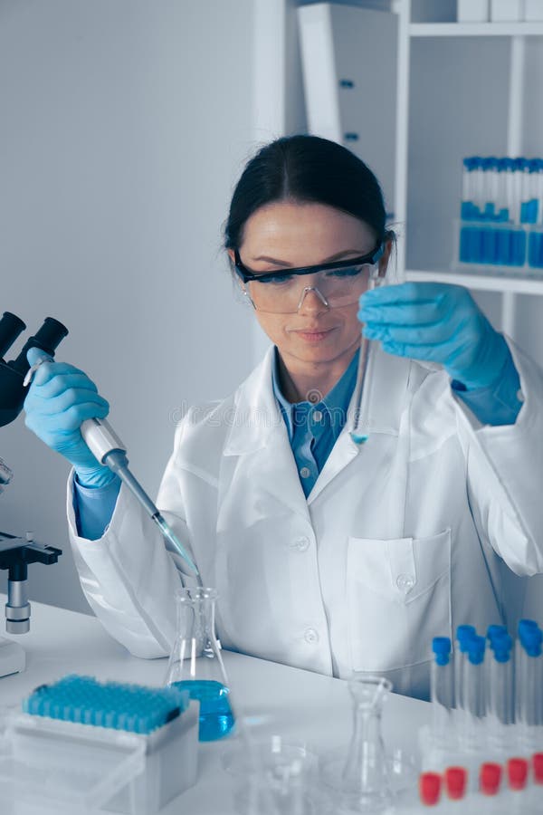 A Skilled Female Scientist is Conducting a Complex Experiment with a ...