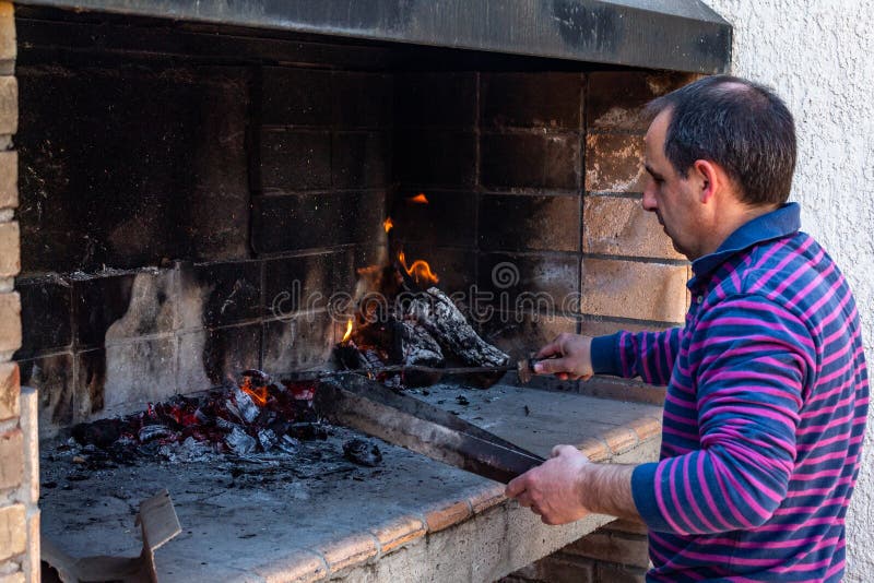 Skilled Man Setting the Fire To Cook a Roasted Meat. Stock Photo ...