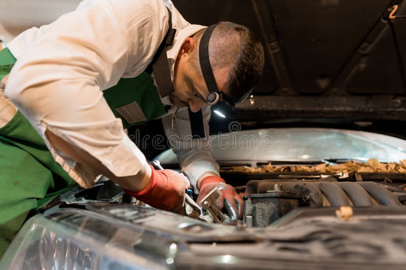 Skilled Mechanic Repairing Engine Under Hood with Professional Tools ...
