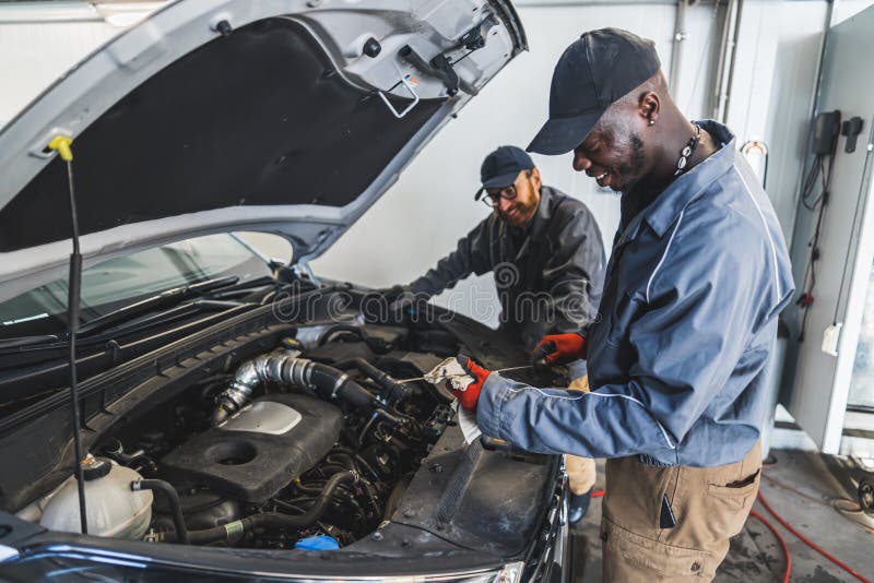 Skilled Mechanics Inspecting Car Engine Using Tools in a Modern Auto ...