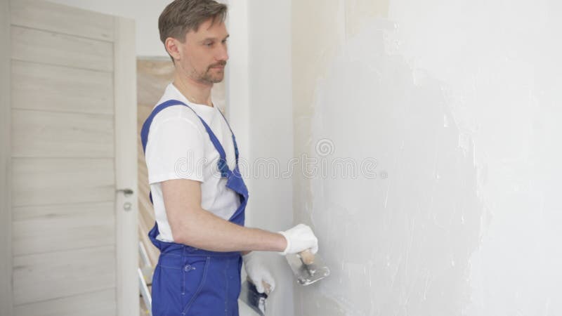 Skilled Plasterer Spreading Smoothing Compound Over Wall Surface ...
