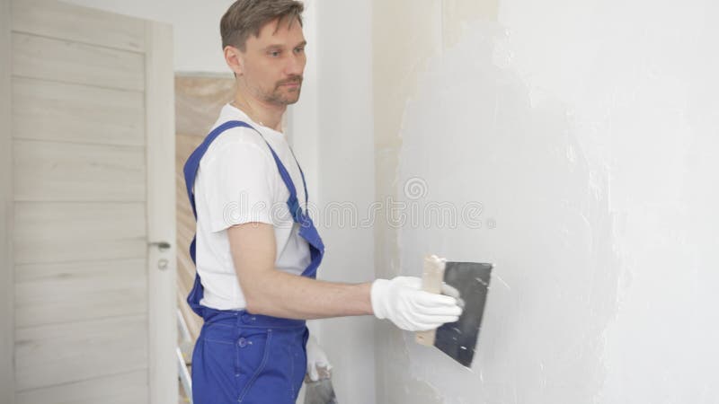 Skilled Plasterer Spreading Smoothing Compound Over Wall Surface ...