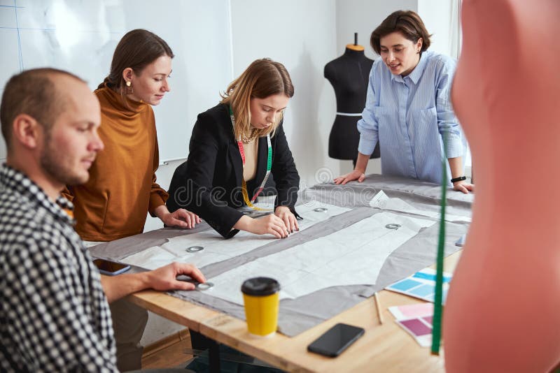 Skilled Tailors Watching Their Colleague Using Patterns Stock Photo ...
