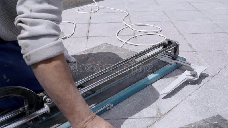 Skilled Worker Using a Tile Cutter Tool on a Stone Surface ...