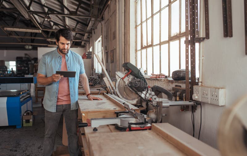Young Woodworker Using a Tablet in His Carpentry Workshop Stock Photo ...