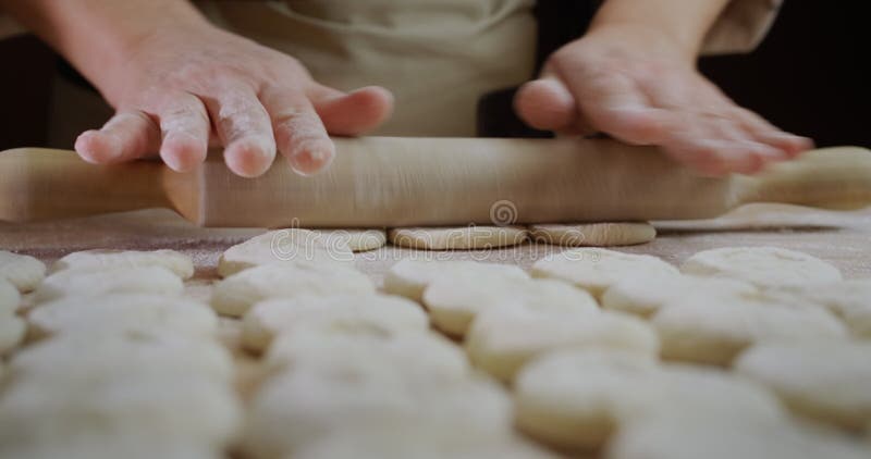 A Skillful Baker Rolls Out Dough for Baking. His Movements are Fast and ...