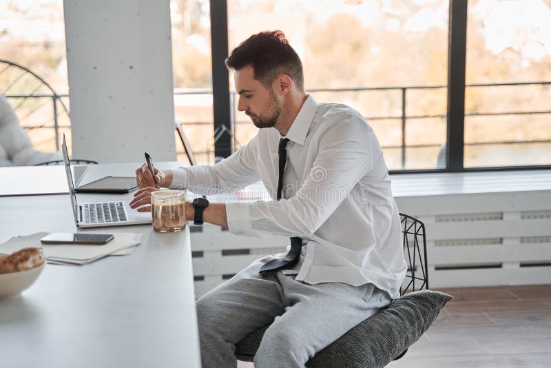 Skillful Entrepreneur Sitting at the Table and Using His Laptop while ...