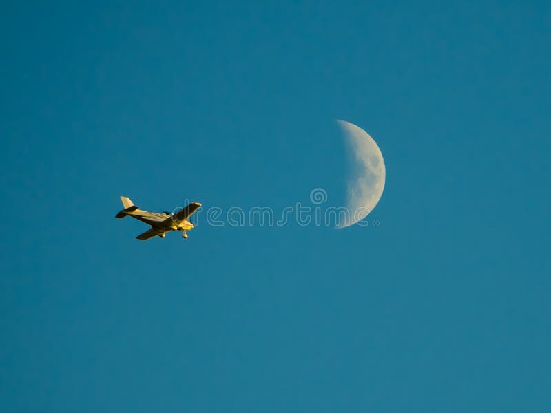 Airplane Flying Under Sunlit Moon in Blue Sky Stock Photo - Image of ...