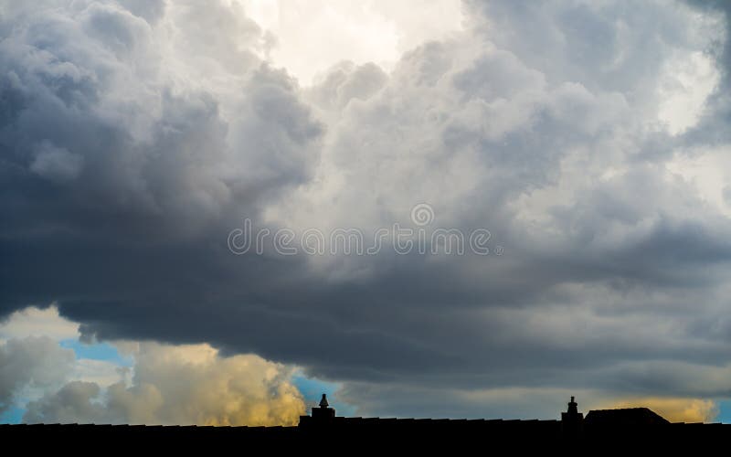 Thunderclouds over rooftop stock image. Image of clouds - 258656457