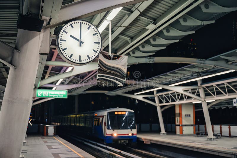 Sky Train Arriving on Platform and Big Clock in Bangkok Metropolis ...
