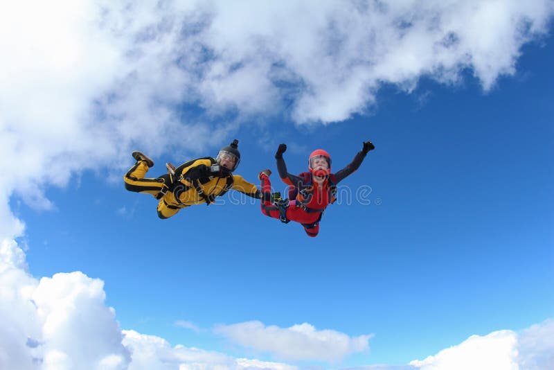 Two Skydivers in Color Suits are Falling in the Clouds. Stock Photo ...