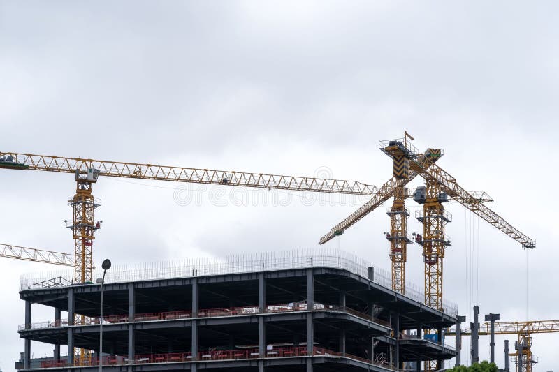 Skyline of a City with Multiple Construction Cranes Alongside a Tall ...