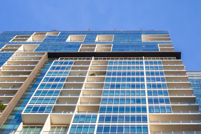 Skyscraper with Large Blue Windows Against the Sky, View from Below ...