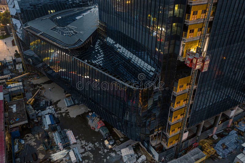 Skyscraper Under Construction in the Evening, Decorated with Glass ...