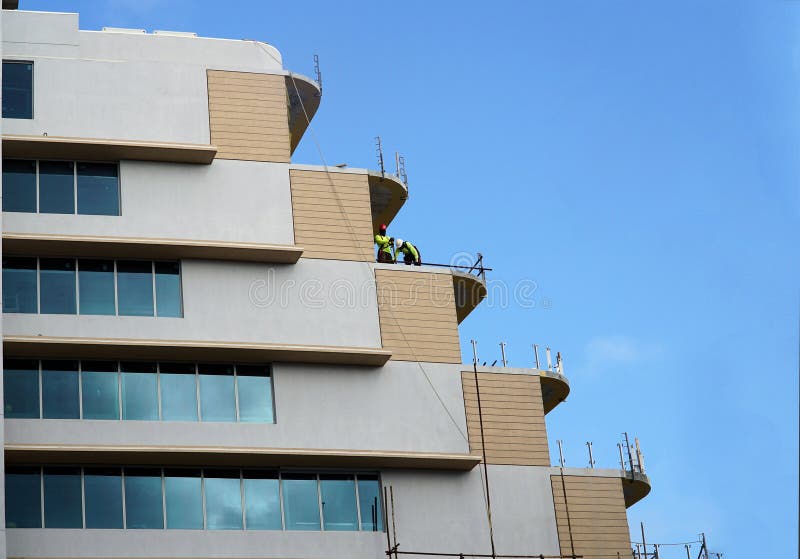 A Skyscraper Under Construction with Men Working on the Outside of the ...