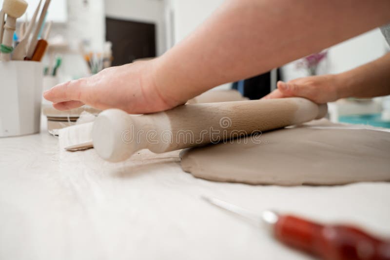 Slab Building Method in Ceramics Crafting. Using a Wooden Stick To Roll Out a Flat Sheet of Clay ...
