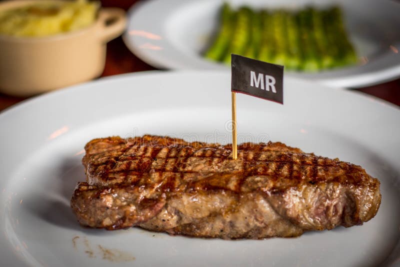 A Slab of Ribeye Beef Steak Done To Medium Rare Served on a Plate Stock ...