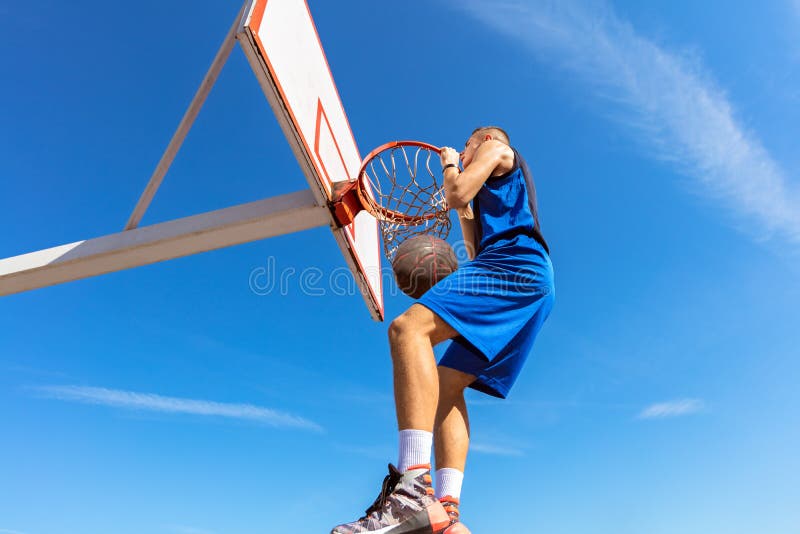 Slam Dunk. Side View of Young Basketball Player Making Slam Dunk Stock ...