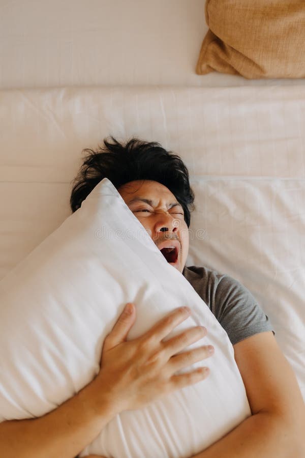 Sleepy Man Keep on Sleeping on the Bed, Using Pillow Covering His Face ...
