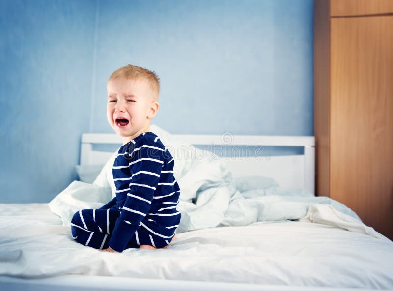 Sleepy boy sitting in bed stock photo. Image of crying - 90370546