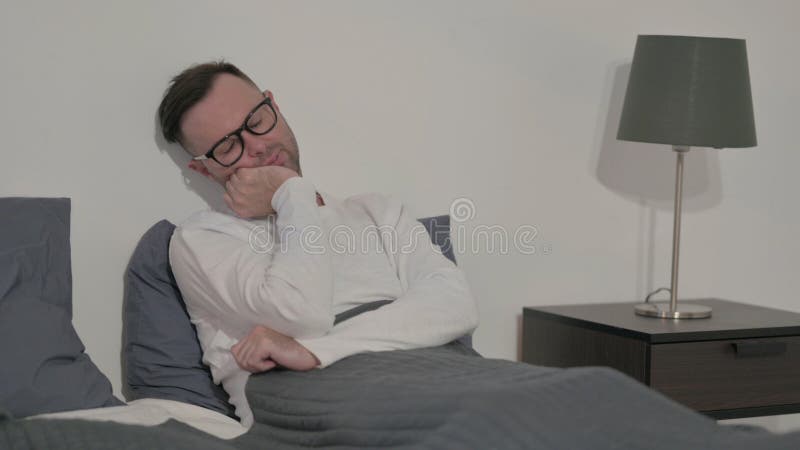 Sleepy Casual Man Taking Nap while Sitting in Bed Stock Photo - Image ...