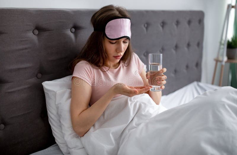 Sleepy Millennial Lady With Glass Of Water Taking Pill Vitamin Or