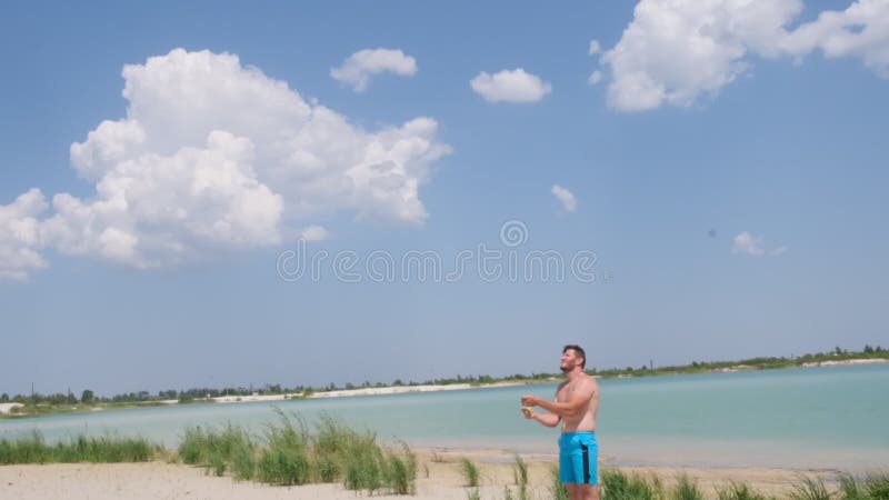 A Slender Man on the Beach is Flying a Multi-colored Kite. Active ...