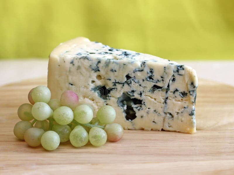 Slice of Blue Cheese with Grapes on Green Background Stock Photo ...