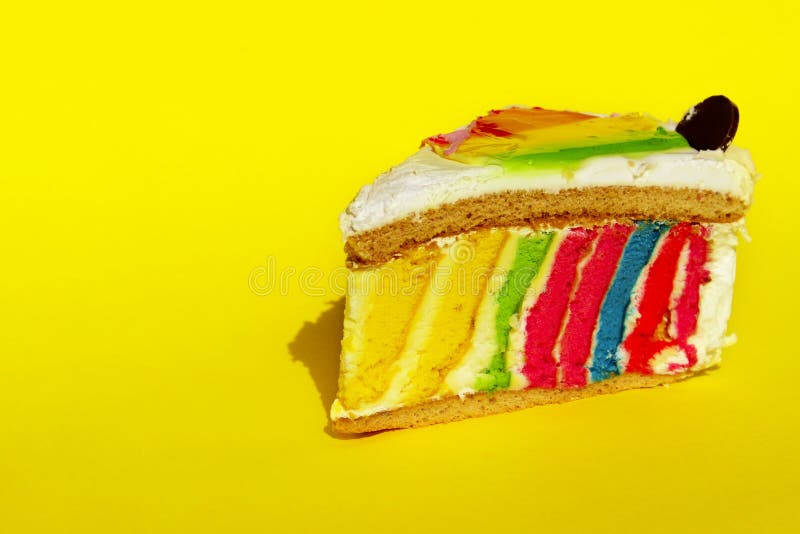A Slice of Delicious Colored Cake on Yellow Background. Rainbow Cake ...