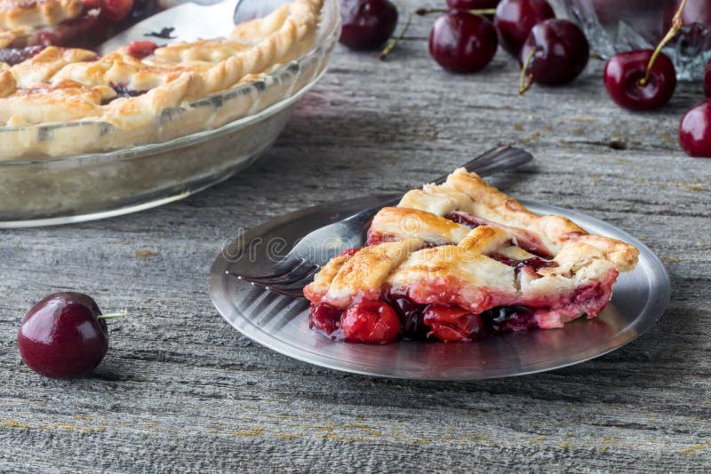 A Slice of Freshly Baked Cherry Pie with the Full Pie in Soft Focus in ...