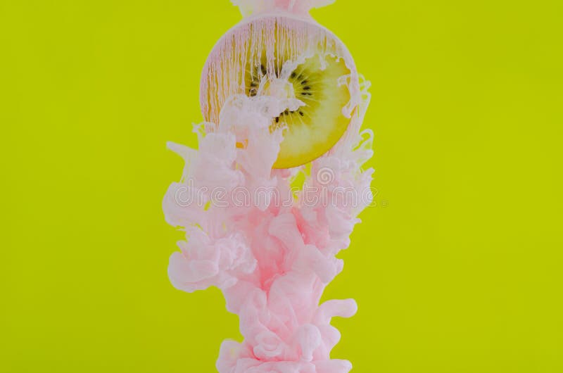 Slice Kiwi Fruit with Partial Focus of Dissolving Pink Poster Color in ...
