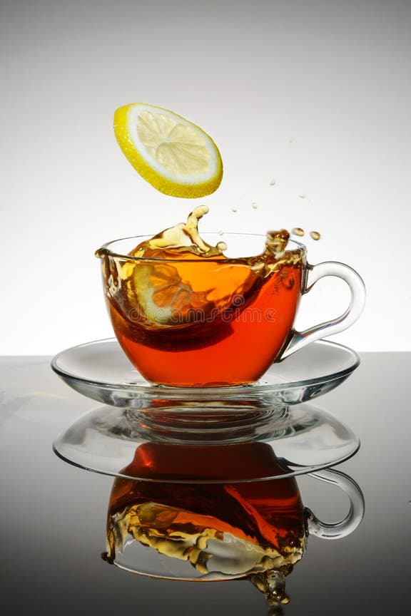 A Slice of Lemon Falls into the Glaas Cup with Tea, Stands on a ...