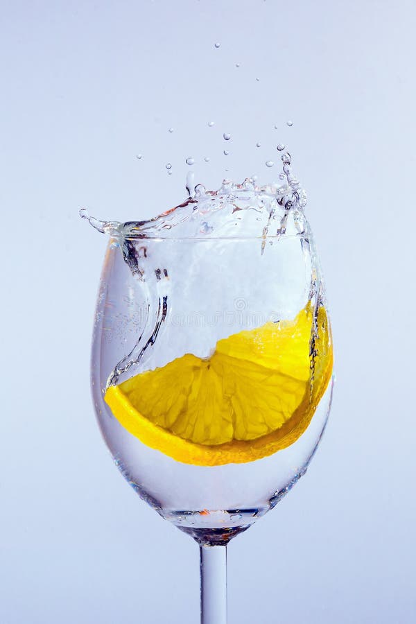 A Slice of Lemon Falls into the Glass with Vodka. Bubbles and Sp Stock ...