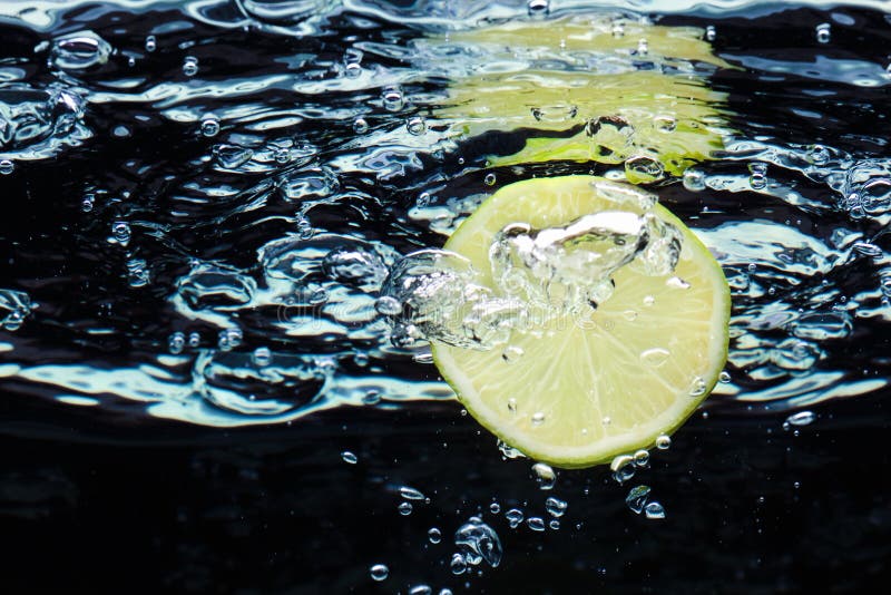 Slice of Lime (lemon) Falling in Water Stock Image - Image of close ...
