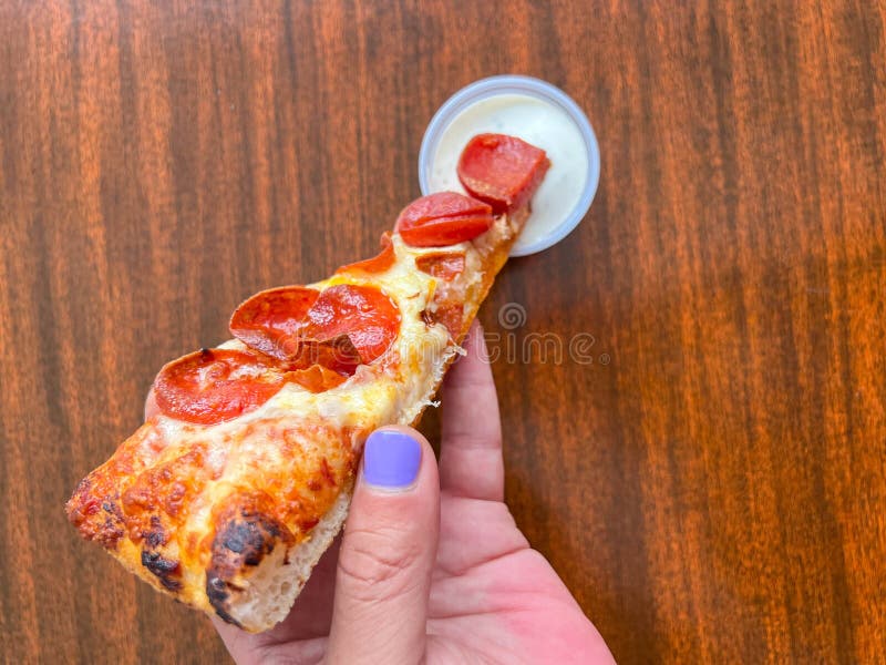A Slice of Pepperoni Pizza Being Dipped into Ranch Dressing Stock Image ...