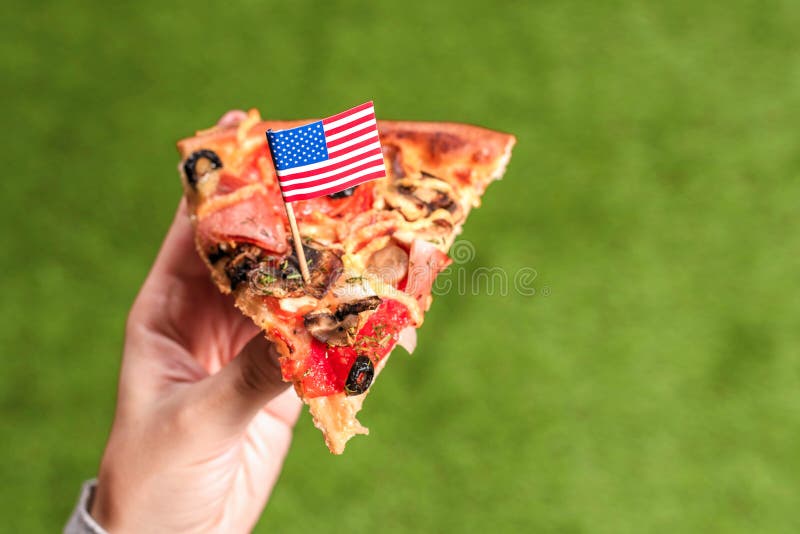 A Slice of Pizza in Female Hands. Lunch on the Green Grass Stock Photo ...