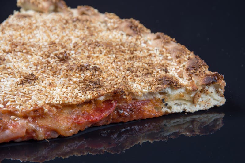 Slice of Pizza with Sesame on the Black Reflections Table Stock Photo ...