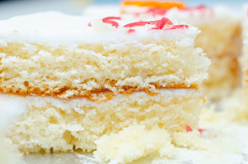 A Slice of White Cake with Color Frosting on Top Stock Photo - Image of ...
