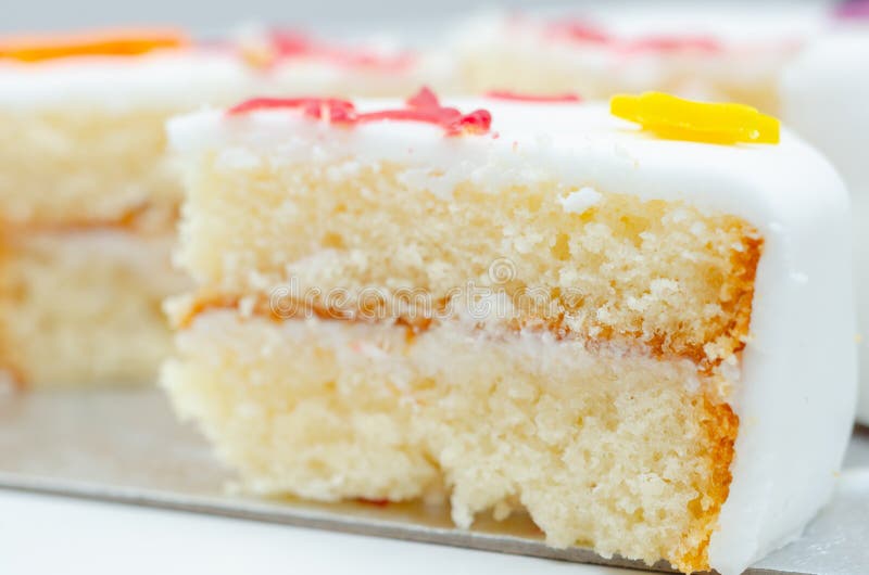 A Slice of White Cake with Color Frosting on Top Stock Image - Image of ...