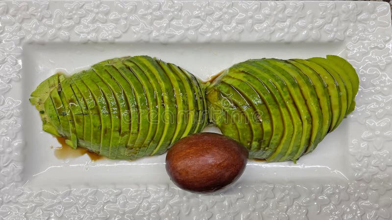 Sliced avocado on a plate stock photo. Image of nature - 352566072