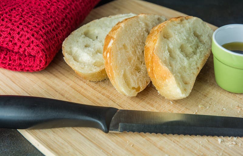Sliced Baguette on Cutting Board with Oil Cloth and Knife Stock Photo ...