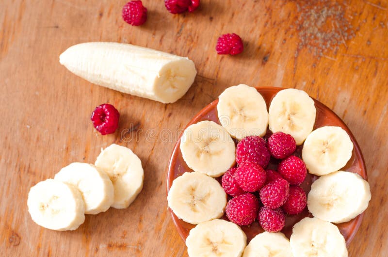 Sliced Banana with Raspberries on the Brown Plate. Horizontal, Top View ...