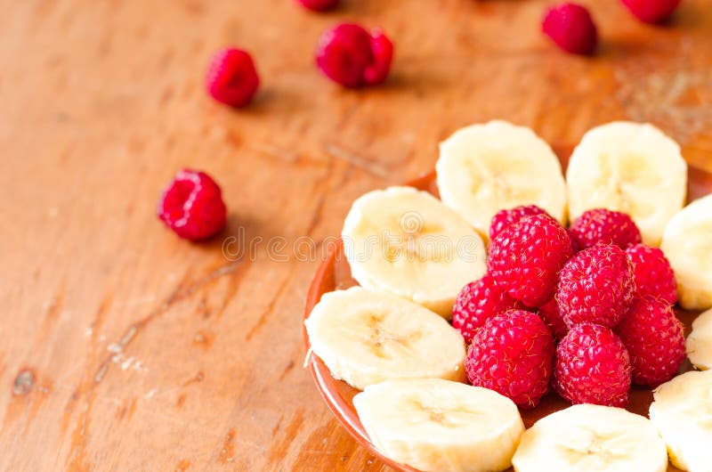 Sliced Banana with Raspberries on the Brown Plate. Horizontal, Top View ...