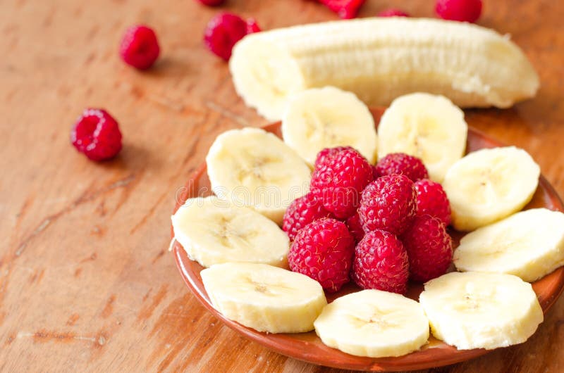 Sliced Banana with Raspberries on the Brown Plate. Horizontal, Top View ...